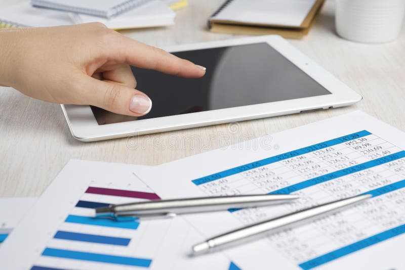 Hand Touching Tablet Computer Screen on Table with Business Paper Stock ...