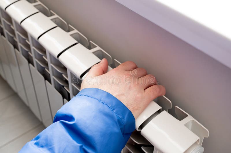 Hand Touching a Warm Radiator in a Home Setting To Check Heating ...
