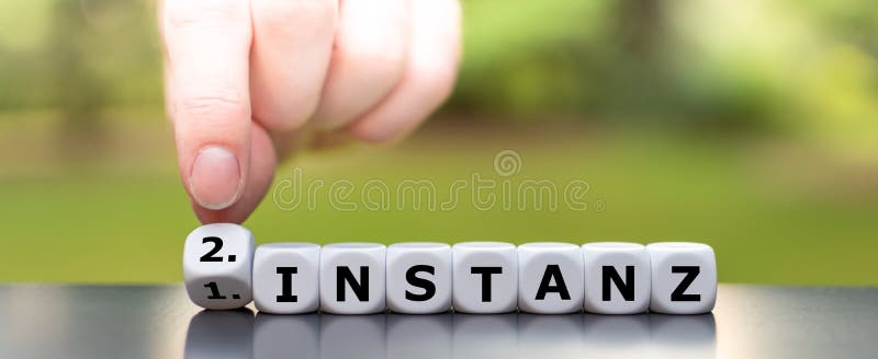 Hand Turns Dice and Changes the German Expression `1. Instanz` First ...