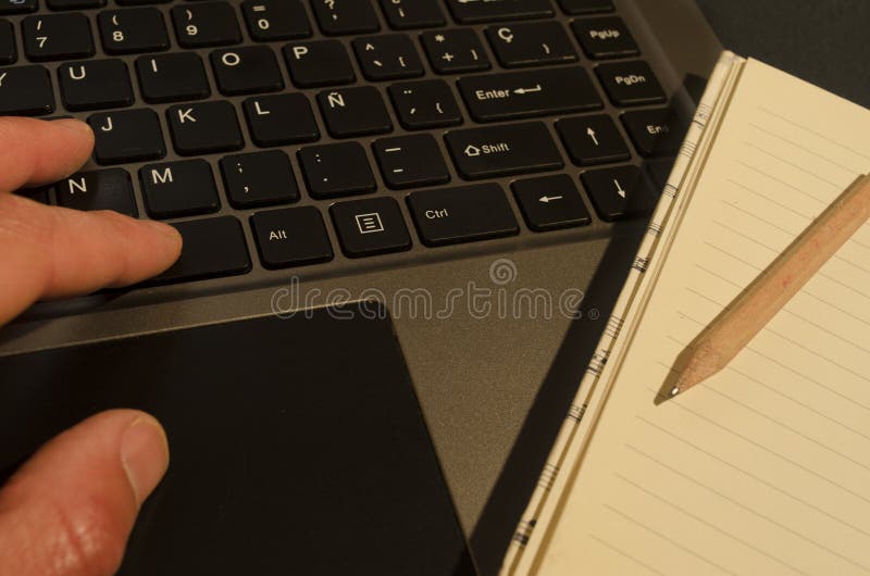 Hand Typing on Computer Keyboard with Notepad beside Stock Image ...