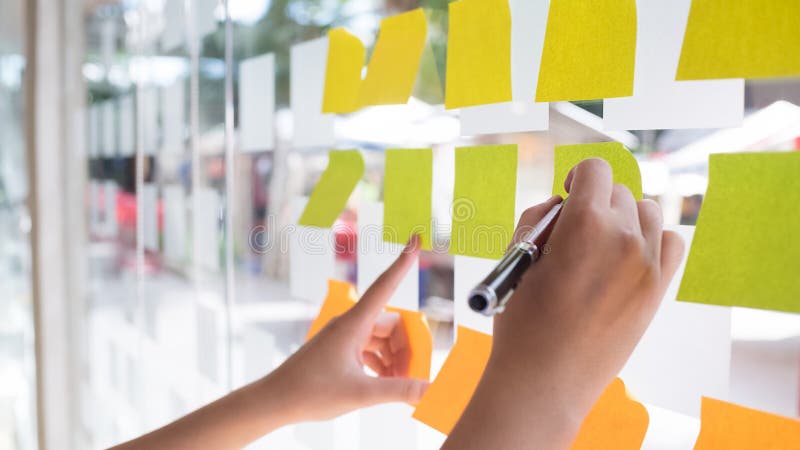Hand Using Post it Sticky Note with Brainstorming on Note Paper. Stock ...