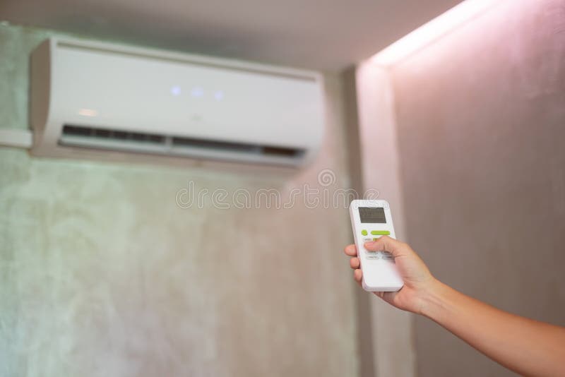 Hand Using Remote Controller for Adjust Air Conditioner Inside the Room ...