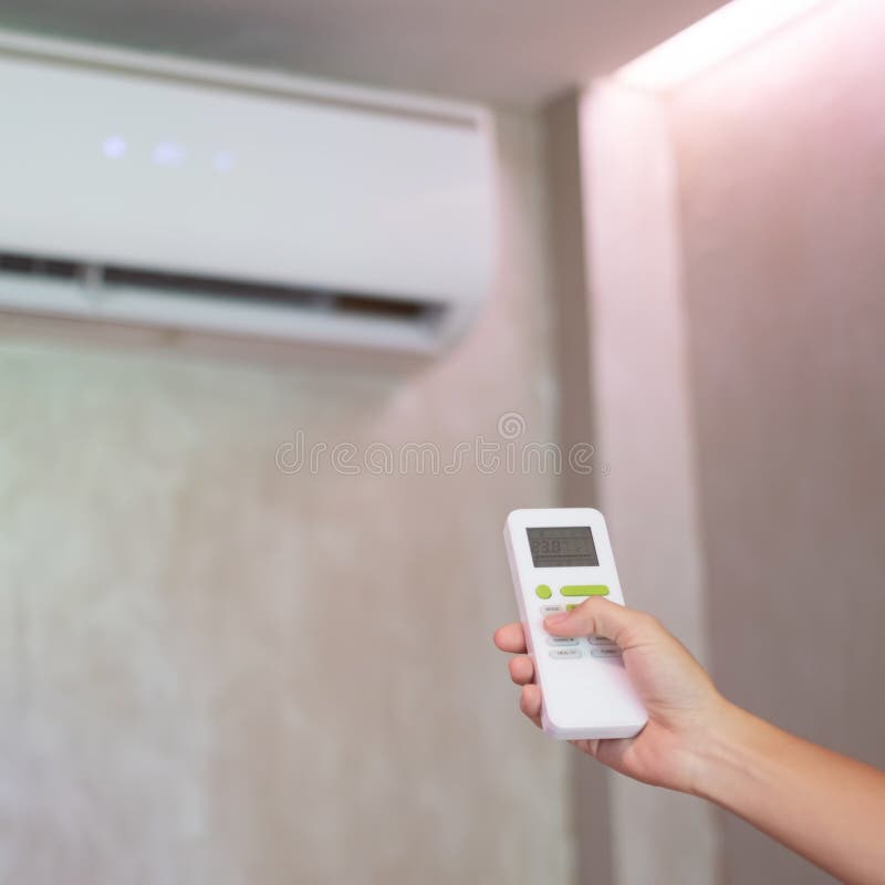 Hand Using Remote Controller for Adjust Air Conditioner Inside the Room ...