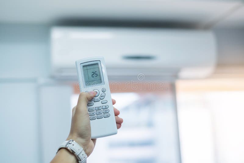 Hand Using Remote Controller for Adjust Air Conditioner Inside the Room ...