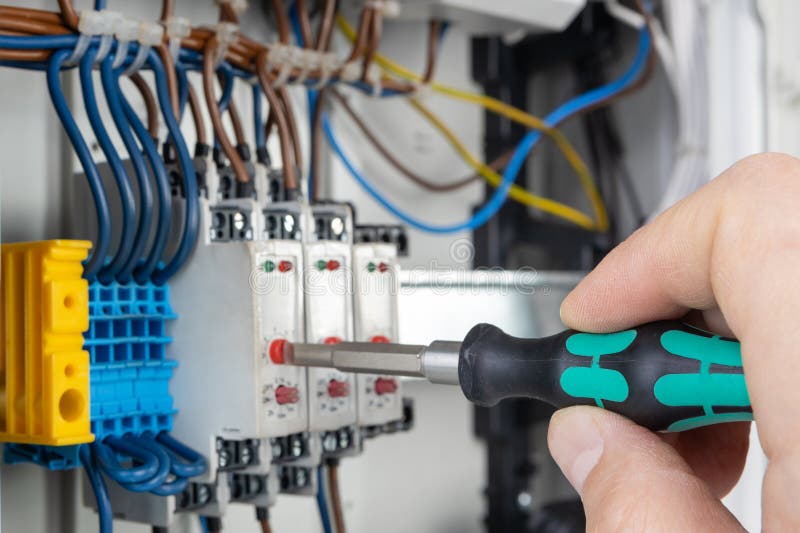 Hand Using Screwdriver on Electrical Terminal Block Stock Photo - Image ...