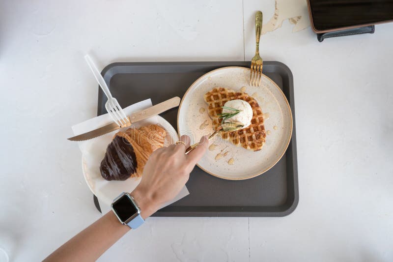 Hand Using Spoon Scooping Ice Cream Waffle and Croissant on White Table ...