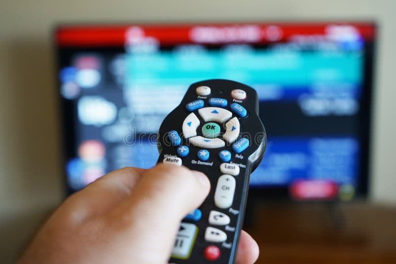 Hand Using TV Remote Control with Television Out of Focus Stock Photo ...