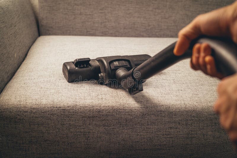 Hand Using Vacuum Cleaner on the Grey Sofa Stock Photo - Image of young ...