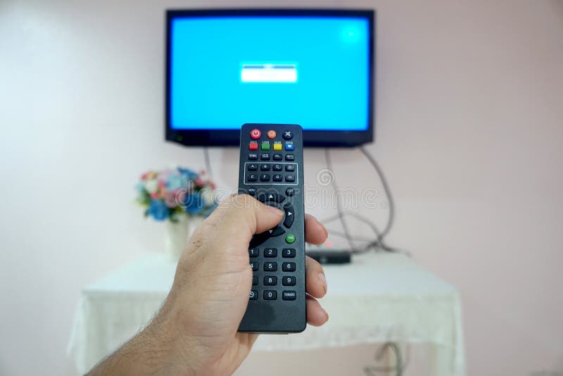 The Hand Was Holding the TV Remote and Pressing a Button on the Remote ...