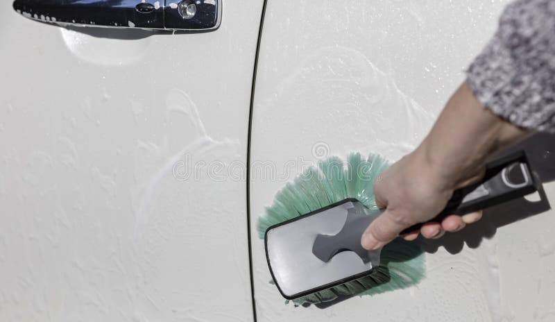 A Hand Washing the Side of a White Car Using a Brush and Soapy Water ...