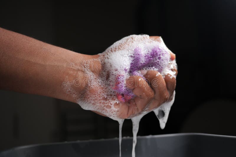 Hand Washing a Soapy Sponge Over a Container of Water Stock Photo ...
