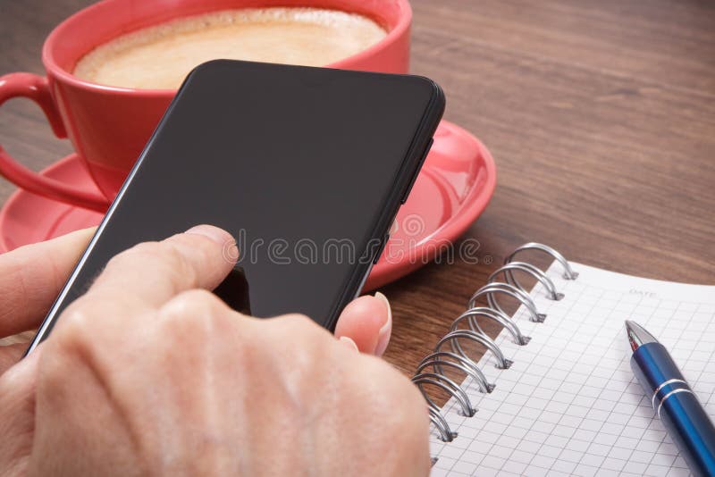 Hand of Woman with Smartphone, Coffee with Milk and Notepad for Writing ...