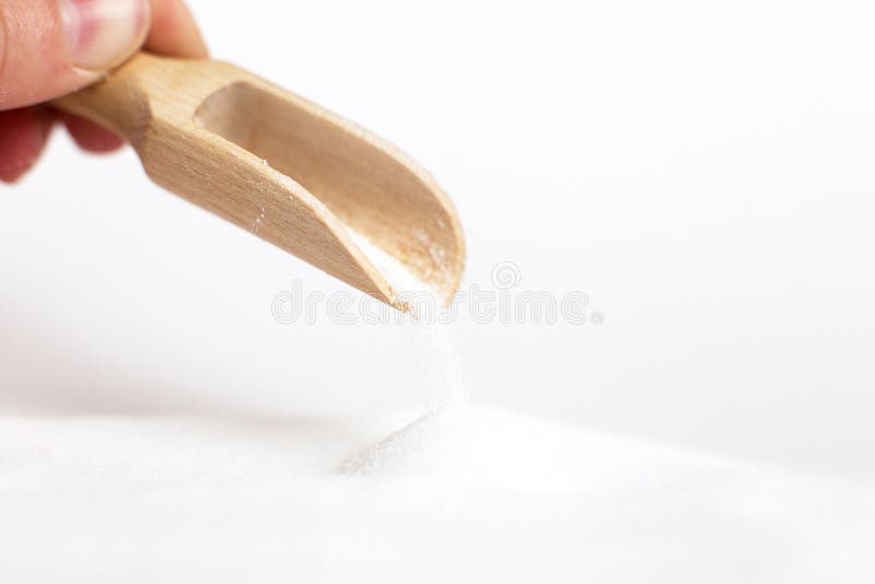 Hand with a Wooden Spoon of Salt Grain on White Background Stock Photo ...