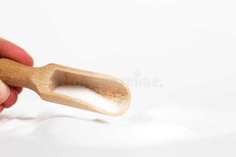 Hand with a Wooden Spoon of Salt Grain on White Background Stock Image ...