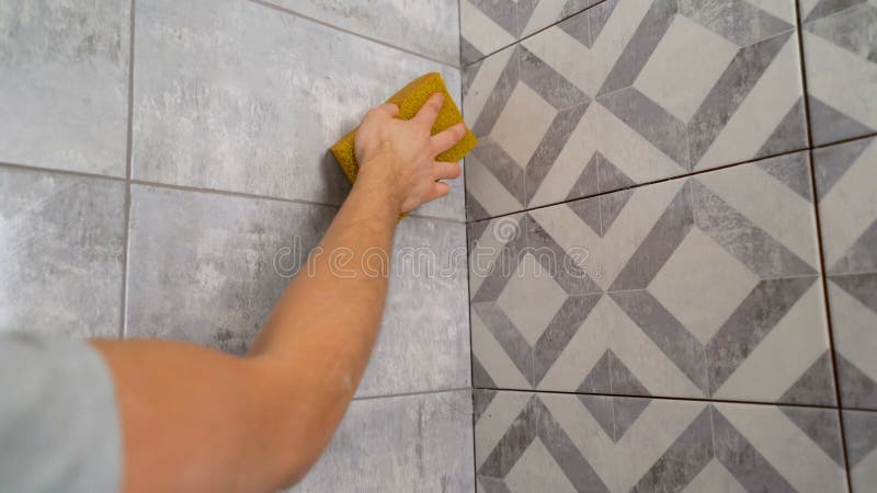 The Hand of a Worker Cleaning Ceramic Tiles. Close-up of Hands Cleaning ...