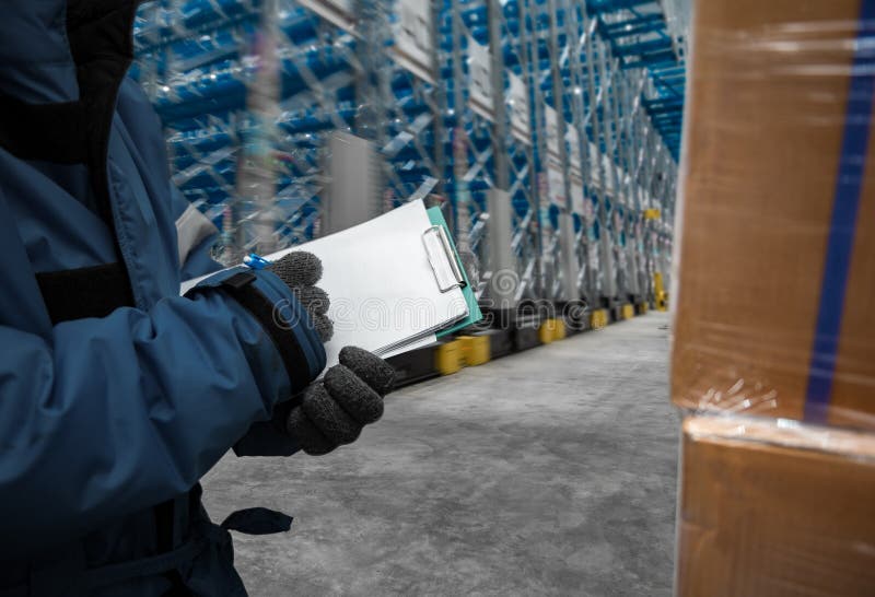 Hand of Worker with a Clipboard Checking Goods in Freezing Room or ...