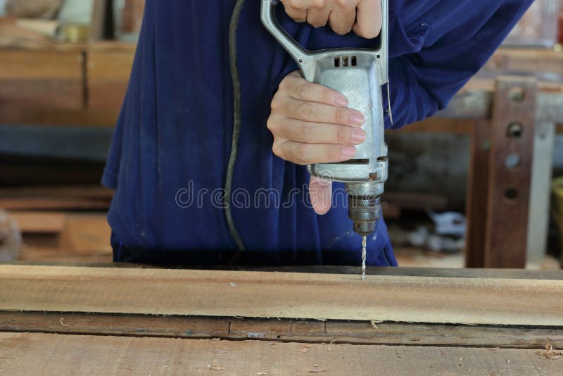 Hand of Worker Drills a Hole with Wooden Plank Using Electric Drill ...