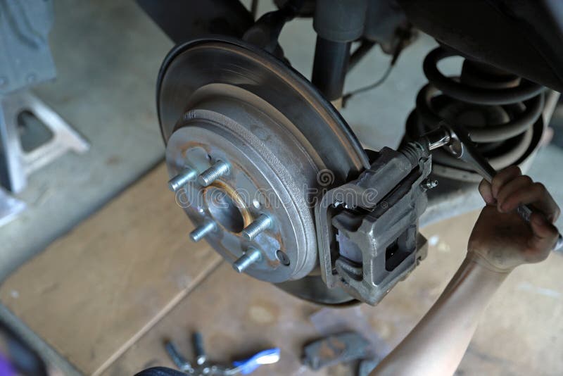 Hand Working on Disc Brake Rotor and Pads on a Vehicle Stock Photo ...