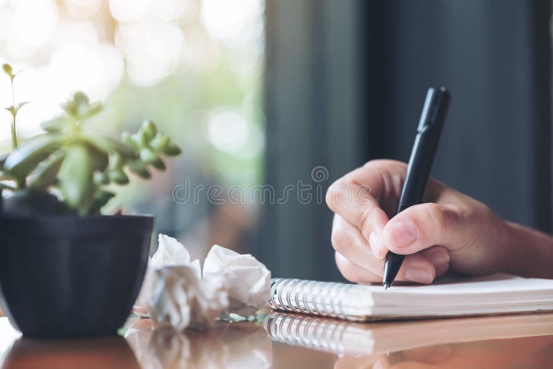 A Hand Working and Writing Down on a White Blank Notebook with Screwed ...