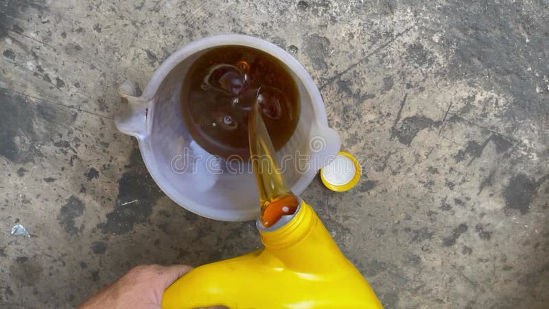 The Hand of a Workshop Worker Pouring Oil Using a Funnel for Servicing ...