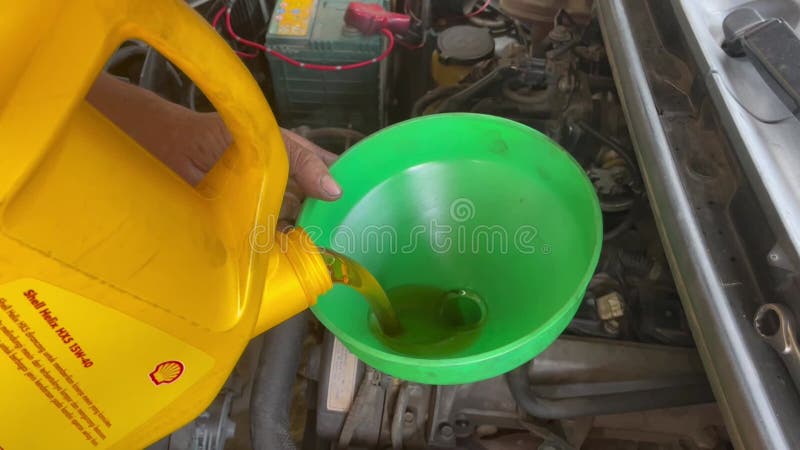 The Hand of a Workshop Worker Pouring Oil Using a Funnel for Servicing ...