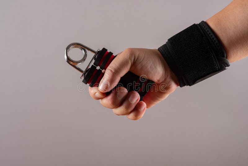 Hand with a Wrist Protective Strap Doing Exercises by Squeezing a Shape ...
