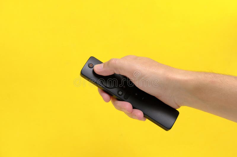 Hand Yellow Background Holds TV Remote by Pressing Button with Finger ...