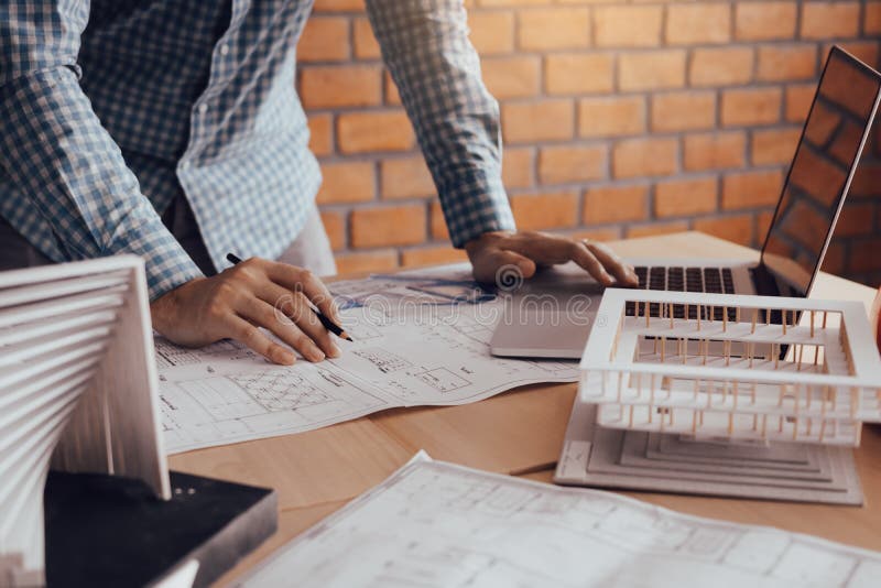 Hand of Young Engineering Man Drawing on Blueprint with Model on Desk ...