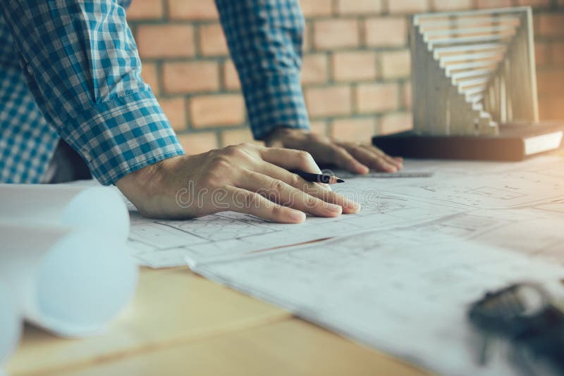 Hand of Young Engineering Man Drawing on Blueprint with Model on Desk ...