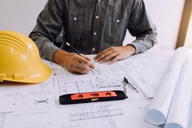 Hand of Young Engineering Man Drawing on Blueprint at Table in Office ...