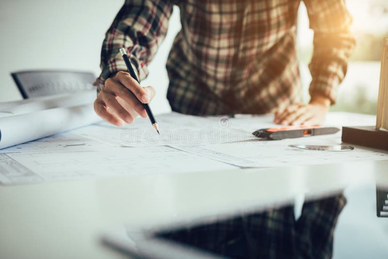 Hand of Young Engineering Man Drawing on Blueprint at Table in Office ...