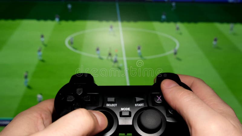 The Hand of a Young Man Playing a Football Computer Game Using a ...