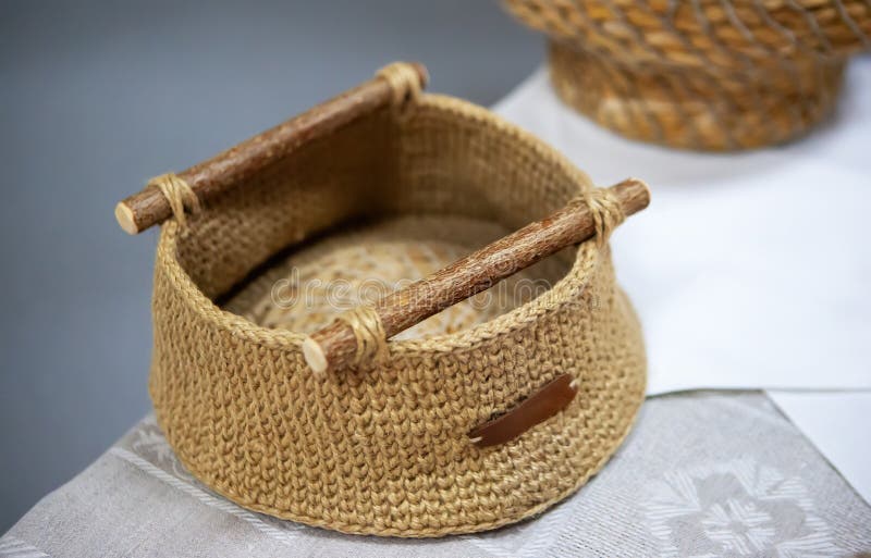 Handcrafted Wicker Basket with Wooden Handles Displayed on a Textile ...