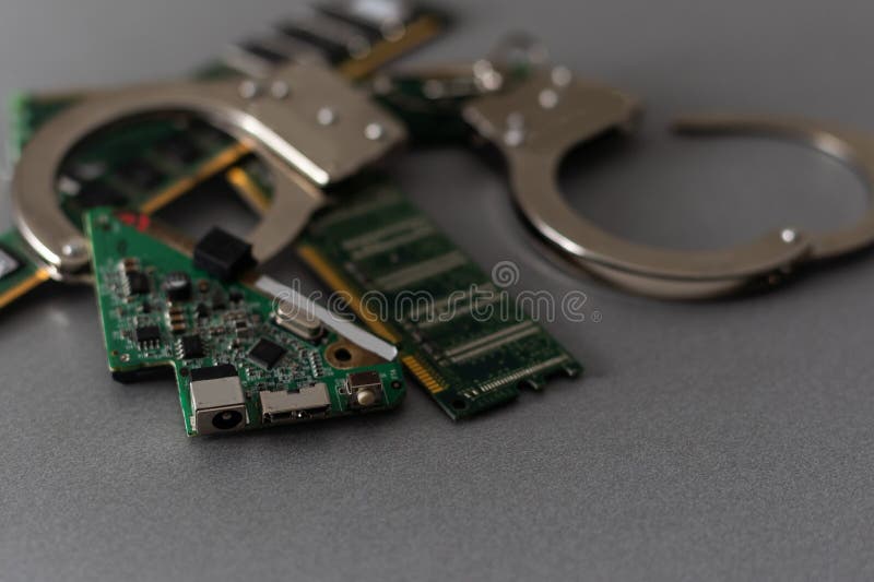 Handcuffs Against a Computer Electronics Board. the Concept of ...