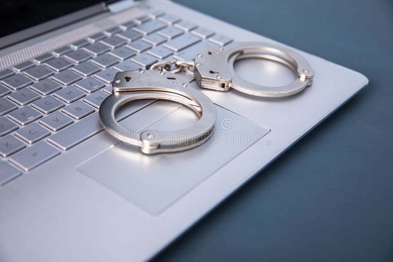 Handcuffs on the computer stock photo. Image of network - 232499488