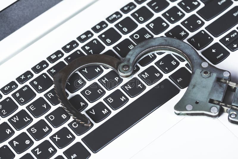 Handcuffs on Computer on Table Stock Photo - Image of keyboard, hacker ...