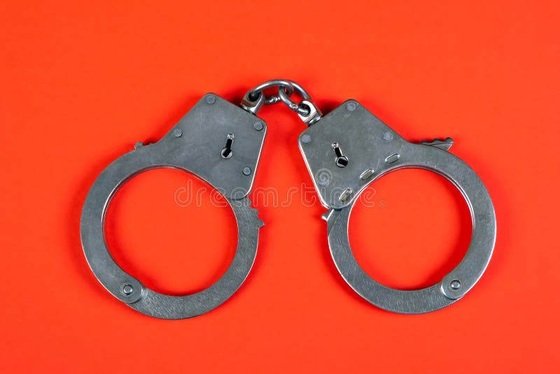 Handcuffs on the Red Paper stock image. Image of pair - 235776967