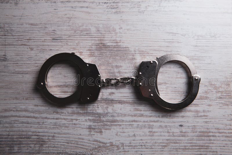 Handcuffs on a Wooden Table Stock Image - Image of wooden, concepts ...