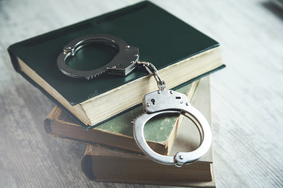 Handcuffs on books stock photo. Image of symbol, legality - 136194110