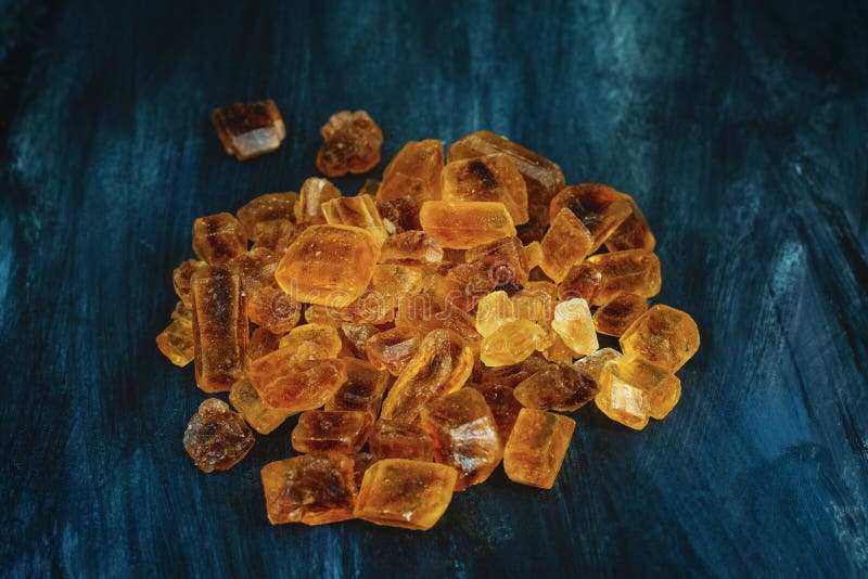 A Handful of Cane Sugar in Solid Slices of Orange Crystals on a Blue ...