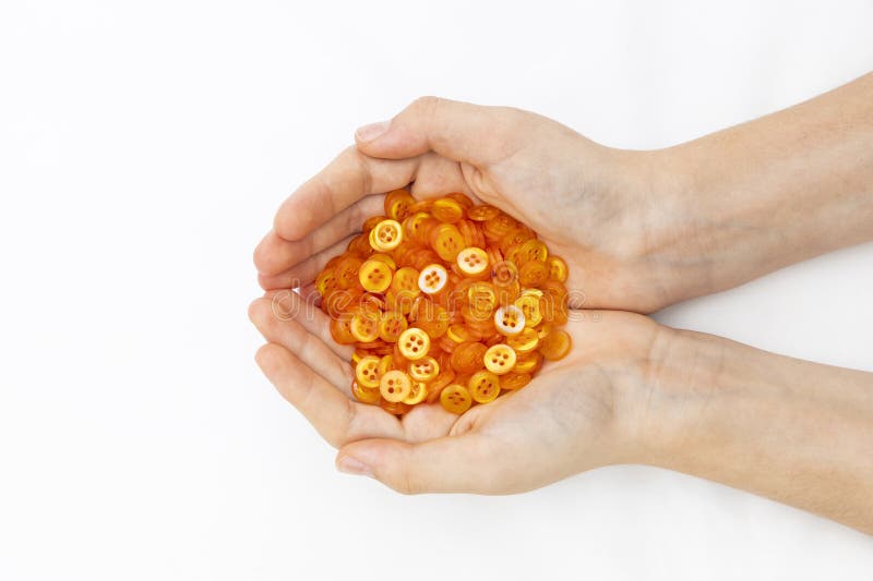 Handful of Orange Buttonhole Buttons in the Hands Stock Photo - Image ...