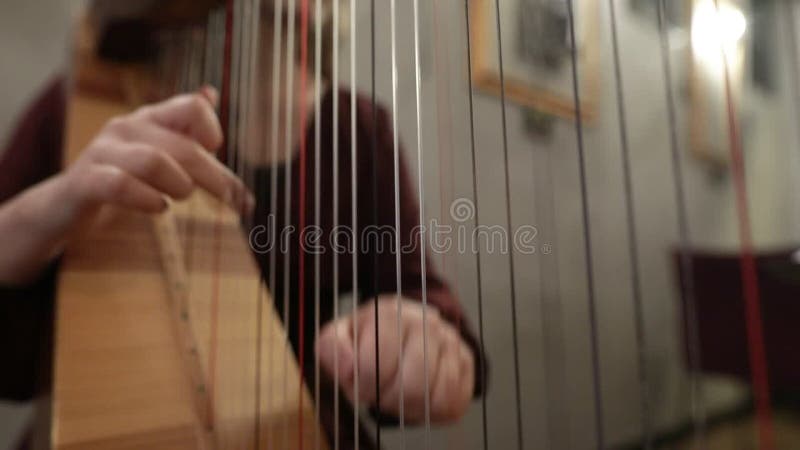 Handheld Footage with Details of the Hands of a Woman Playing a Harp ...