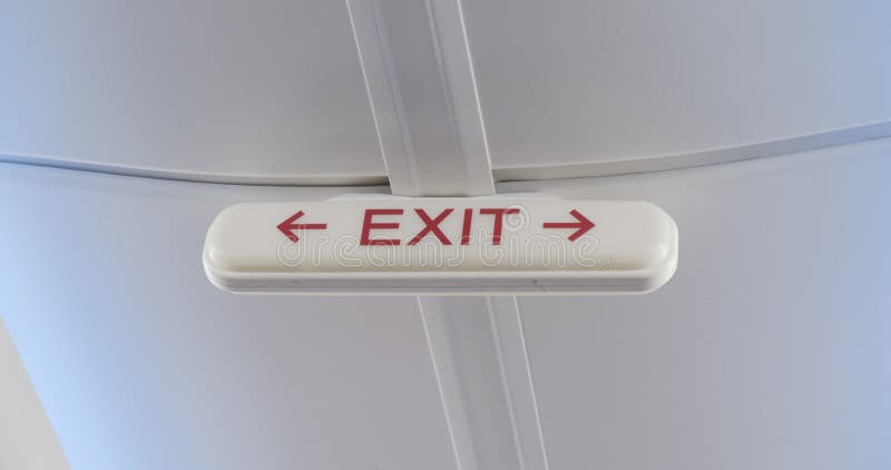 Handheld Shot of Overhead Exit Sign with Left and Right Arrows Inside ...
