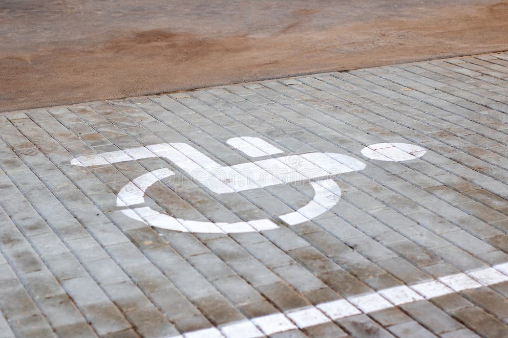 A Handicap Accessibility Sign is Painted on a Brick Pavement Surface ...