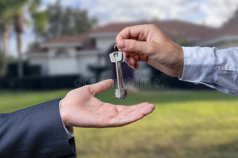 Handing Over the House Keys in Front of a Beautiful New Home. Stock ...