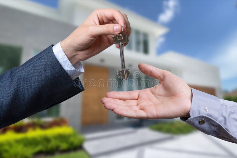 Handing Over the House Keys in Front of a Beautiful New Home. Stock ...