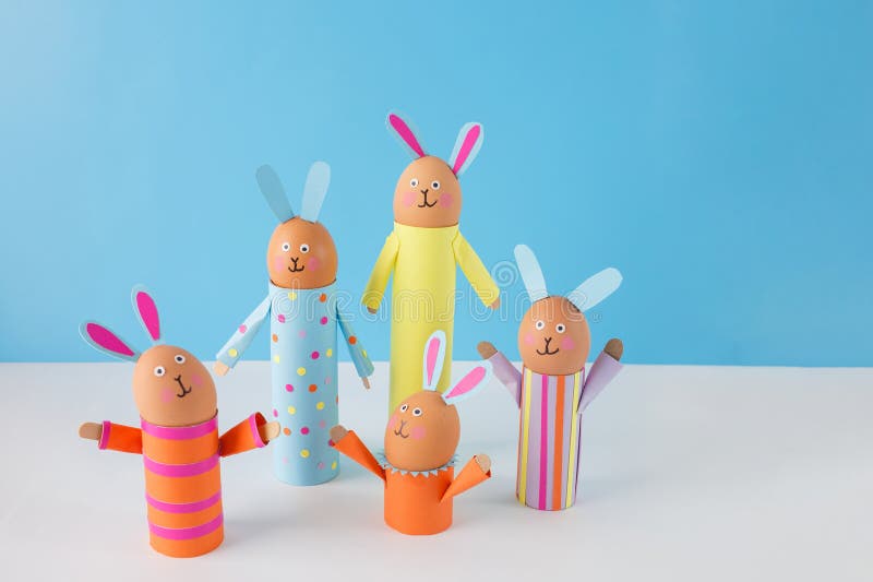 Handmade Easter Bunny Crafts Using Colored Paper and Eggs on a Blue ...