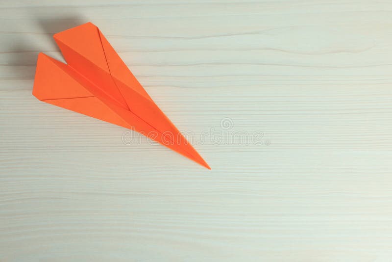 Handmade Orange Paper Plane on Beige Wooden Table, Top View. Space for ...