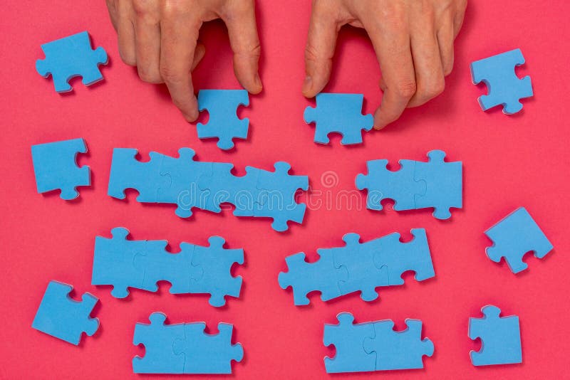 Hands with a Blue Puzzle Pieces on Pink Background Stock Photo - Image ...