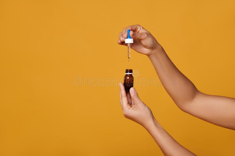 Hands with a Bottle of Oil, Squeezing a Drop of Oil from a Pipette ...
